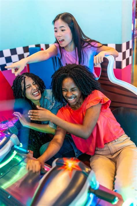 Excited Multiethnic Friends Playing Arcade Game Together Stock Image Image Of Bonding Lights