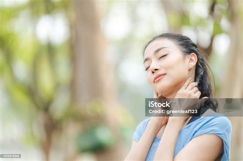 도시의 공원에서 조깅 운동을 한 후 몸과 목을 스트레칭하는 아시아 여성 운동복을 입은 매력적인 운동 선수 소녀는 아침 여름에 야외 라이프 스타일 스포츠 훈련 피트니스 달리기