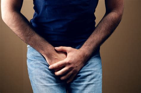 Premium Photo Man Covered His Groin On Brown Background