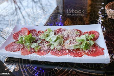 붉은 쇠고기와 돼지고기는 카페 테이블에 흰색 사각형 접시에 채소와 치즈 뿌리고 토마토와의 카르파치오 레스토랑 0명에 대한 스톡 사진 및 기타 이미지 Istock