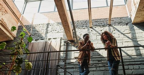 세련된 캐주얼 웨어를 입은 젊은 인종 데이트 로프트 아파트나 스튜디오의 발코니에 서서 회색 벽돌 벽을 들고 대화를 나눴다 사진 Unsplash의 벽돌 벽 이미지