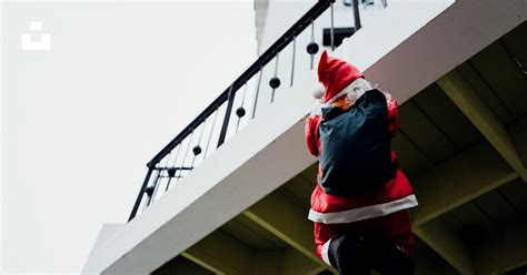 빨간 재킷을 입은 사람이 검은 금속 발코니 울타리에 부착 된 흰색 밧줄을 들고 있습니다 사진 Unsplash의 무료 산타 클로스 이미지