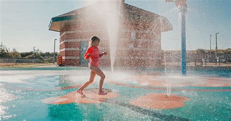 귀여운 사랑스러운 백인 재미있는 소녀가 여름날 스플래시 패드 놀이터에서 놀고 있습니다 물에서 즐거운 시간을 보내는 행복한 아이 야외 어린이를위한 계절 수상 스포츠