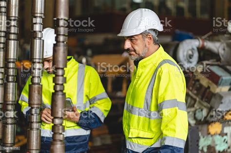 산업 제조 공장에서 일하는 안전 헬멧 하드 모자를 가진 직업적인 기술공 엔지니어 기계장치 생산 기술 또는 건축 운영의 장비를 검사하는 일에 남자 25 29세에 대한 스톡