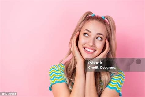 멋진 쾌활한 소녀가 트렌디한 옷을 입고 팔을 만지는 얼굴에 흥미 있는 표정을 짓고 분홍색 배경에 고립된 빈 공간을 닫습니다 20 24세에 대한 스톡 사진 및 기타 이미지