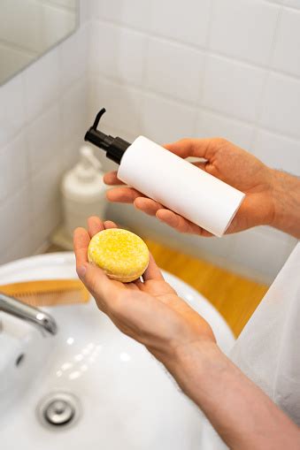 한 남자가 고체 샴푸 바와 액체 샴푸 바 중에서 선택하고 있습니다 욕실 액세서리 플라스틱 프리 제로 웨이스트 생활 낮은 수분 성분 지속 가능한 모발 관리 자연에 대한 책임