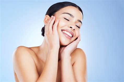 미용 스킨케어 스파 트리트먼트 페이셜 및 화장품을 위한 여성의 얼굴과의 접촉 소녀 모델과 함께 건강 웰빙 미소를 짓고 파란색 배경 스튜디오에서 휴식 자기 관리 및 빛을 위해