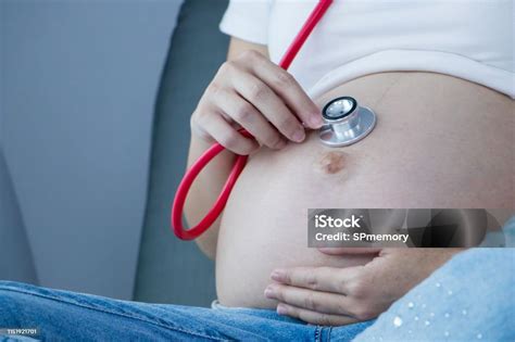 그녀의 배를 듣고 청진 기를 사용 하 여 아름 다운 젊은 임신 한 여성의 초상화 아기의 개념을 준비 하는 임신 건강 관리 십 대 어머니 중 모성 가정 생활에 대한 스톡 사진
