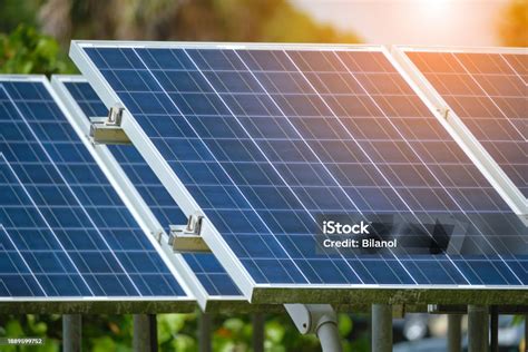 깨끗한 전기의 효과적인 생성을 위해 주차장 근처의 스탠드 프레임에 설치된 태양 전지판 전기 자동차 충전을위한 도시 인프라에 통합 된 태양 광 기술 건축물에 대한 스톡 사진