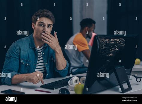 Selective Focus Of Shocked Programmer Looking At Camera While Working