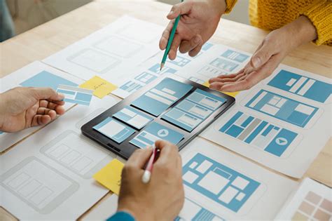Ux 개발자와 Ui 디자이너가 현대 사무실에서 고객 요약 및 색상 코드와 함께 테이블에 모바일 앱 인터페이스 와이어프레임