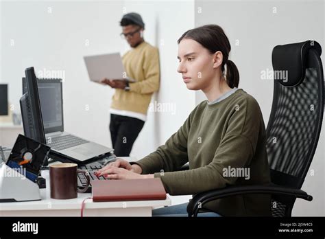 Young Serious Female Programmer In Casualwear Looking At Computer