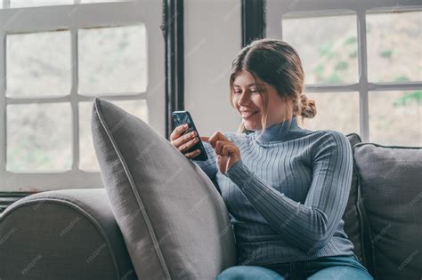Mujer Hermosa Joven Sentada En El Sofá En Casa Charlando Y Navegando