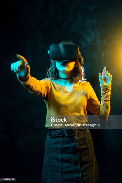 가상 현실 고글을 입고 곱슬 머리를 가진 젊은 소식통 여자와 스튜디오 네온 불빛에 다른 세계를 터치 합니다 Vr 헤드셋을 사용 하 여 스마트 폰 가상현실에 대한 스톡 사진