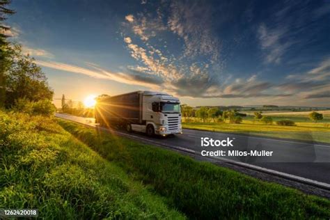 일몰의 광선에 시골 풍경에 아스팔트 도로에 운전 흰색 트럭 운전하기에 대한 스톡 사진 및 기타 이미지 운전하기 배달 봄 Istock