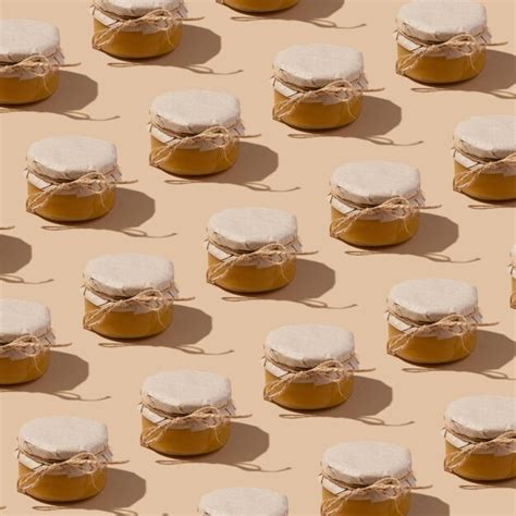 Premium Photo Pattern From Glass Jar With Honey Under Kraft Paper On A String On Beige