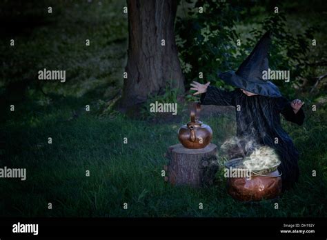 Little Halloween Witch Boiling A Potion Outdoors In The Woods Stock