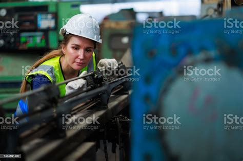 안전 하드 햇 헬멧을 착용 한 백인 여성 엔지니어링 근로자는 자동 로봇 선반 기계를 검사하여 부품을 드릴링합니다 금속 선반 산업 제조 공장 30 34세에 대한 스톡 사진 및