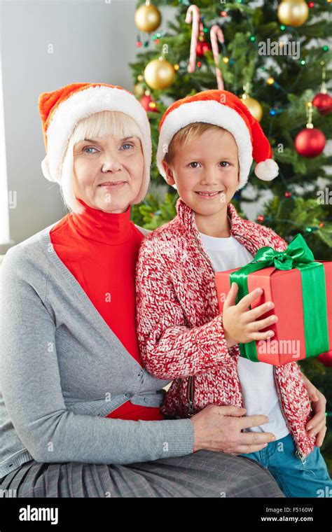 Mature Woman Holding Her Grandson With T Box And Both Looking At