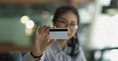 흐릿한 배경에 신용 카드를 보여주는 사업가의 클로즈업 보기 사진 Unsplash의 사진술 이미지