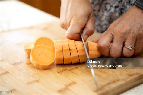 나무 도마에 부엌 칼로 슬라이스에 껍질을 벗긴 고구마를 절단 여성의 손의 클로즈업 고구마에 대한 스톡 사진 및 기타 이미지 고구마 음식 썰기 가정 생활 Istock