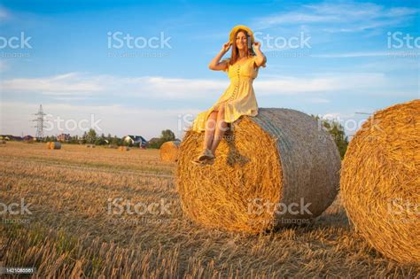 노란 드레스와 모자를 쓴 젊은 예쁜 여자가 일몰 시간에 건초 더미로 필드 배경에 닫힙니다 30 34세에 대한 스톡 사진 및 기타 이미지 30 34세 건초 식물 건초