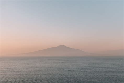 경치가 좋은 고요한 고요함 구름 덮개 그림 같은 난색 낭만적인 대기의 랜드마크 먼 전망 무성한 물 미묘한 바다 바다 경치 산 산악 해안 생생한