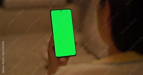 Vidéo Stock 녹색 목업 화면이 떠 있는 스마트폰을 쓰는 여성을 어깨 너머에서 본 영상 Adobe Stock