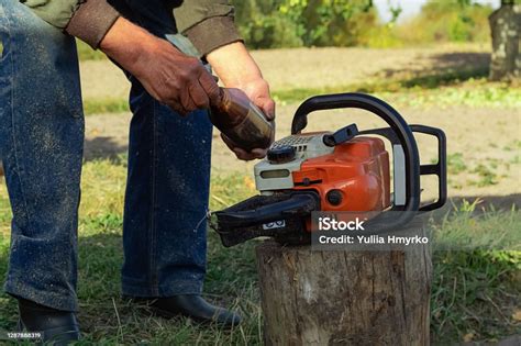 한 남자의 손이 전기톱에 연료를 공급한 후 휘발유 한 병을 닫습니다 가솔린에 대한 스톡 사진 및 기타 이미지 가솔린 갈색 개념 Istock