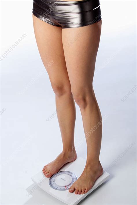 Woman Standing On A Scale Stock Image C032 6693 Science Photo Library