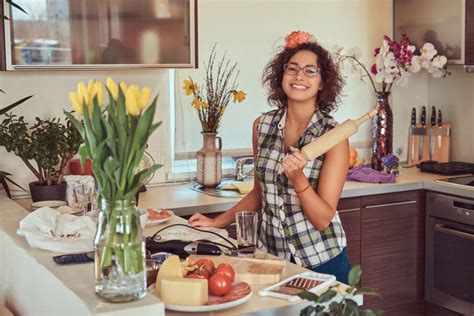 Muchacha Hispánica Rizada Encantadora Que Cocina En Su Cocina Foto De