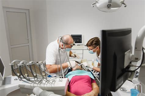 준비 하 고 치과 세라믹 크라운 설치의 과정입니다 남성 전문 치과 의사와 여성 조 수 현대 도구 장비 클리닉 빛 사무실에 여자 환자의 치아 치료에 도움이 됩니다 건강 진단에