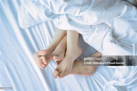 Close Up Barefoot Legs Of Lesbian Couple Lovers Sleep On White Bed In