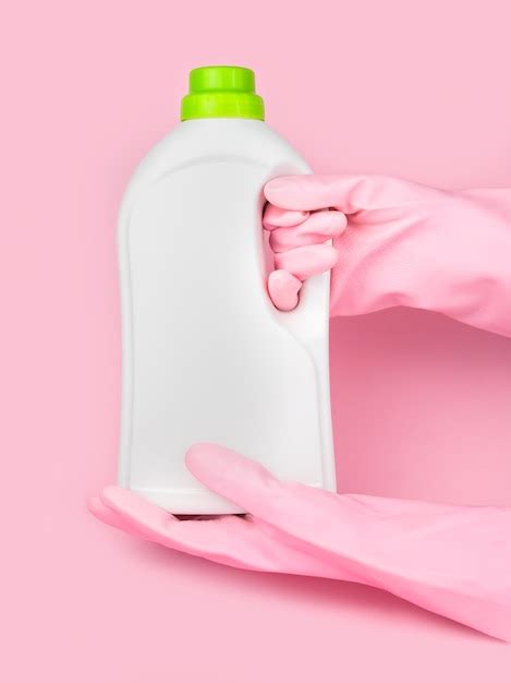 Premium Photo A Hands In A Pink Rubber Gloves Holds A Bottle Of