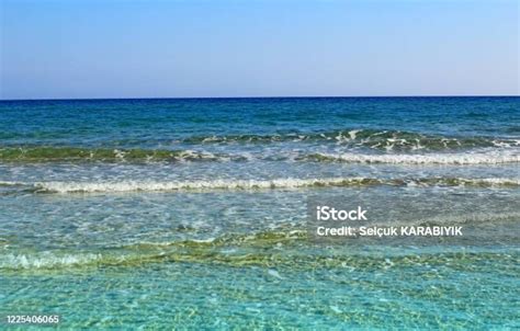 Langit Yang Cerah Laut Seperti Kolam Renang Dan Ombak Kecil Menghantam Pantai Foto Stok Unduh