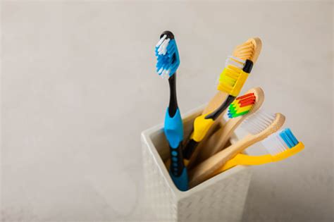 회색 배경의 유리에 여러 가지 색의 칫솔 세트를 클로즈업합니다 치과 개념 구강 관리 욕실을위한 화장품의 개념 측면보기 복사 공간