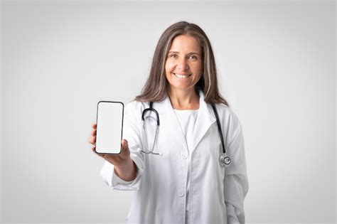 Sympathique femme médecin senior en blouse blanche avec stéthoscope