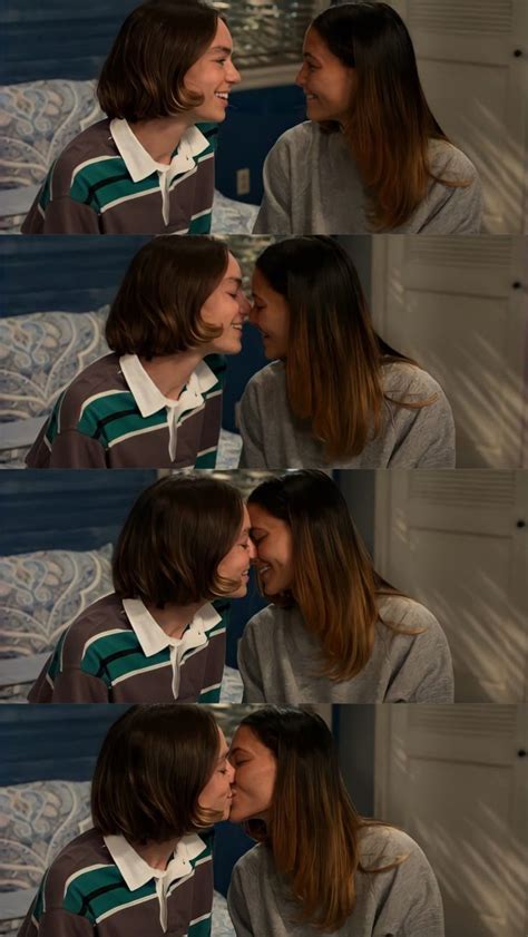 Two People Kissing Each Other In Front Of A Wall