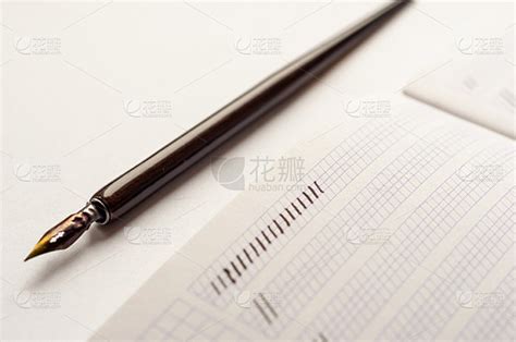 手里拿着笔，桌上放着笔记本。学习的概念。