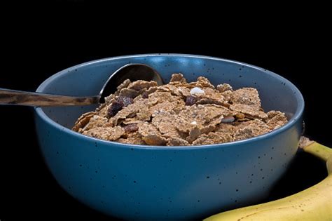 바나나와 건포도를 포함한 말린 과일을 곁들인 밀기울 플레이크 한 그릇 과일과 섬유질의 좋은 혼합물 밀기울 플레이크에 대한 스톡 사진 및 기타 이미지 Istock