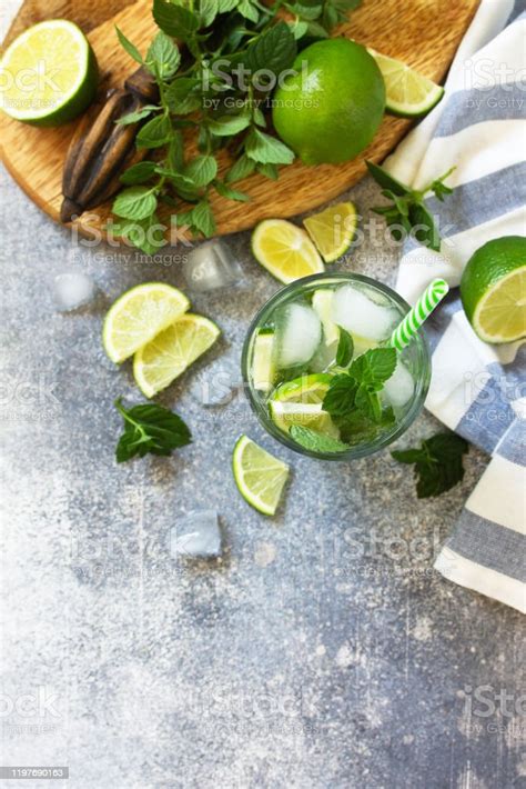 여름 의 차가운 음료와 칵테일 라임 얼음 민트가 있는 신선한 모히토 칵테일이 회색 돌 배경의 유리잔에 담니다 상단보기 평면 누워 배경입니다 공간을 복사합니다 0명에 대한