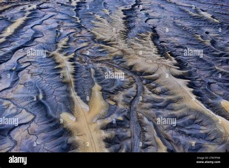 Aerial View Of Intricate River Patterns With Sediment In The Water Creating Abstract Shapes