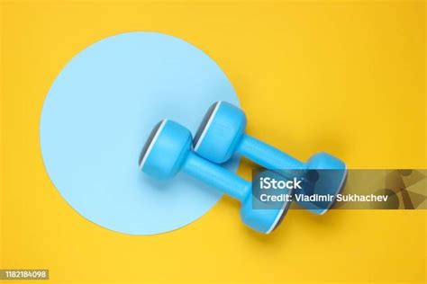 파란색 파스텔 원노란색 배경에 플라스틱 아령 맨 위 보기 미니멀리즘 스포츠 컨셉 맨 위 보기 개념에 대한 스톡 사진 및 기타 이미지 Istock