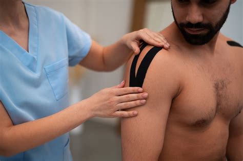 Free Photo Female Therapist In The Rehabilitation Center Putting Shoulder Support On Man