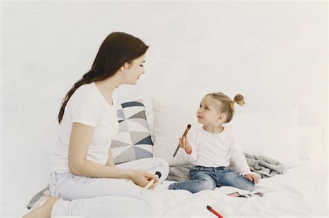 Maman Jouant Avec Des Cosmétiques Au Lit Avec Sa Fille Photo Gratuite