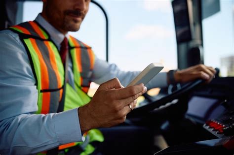 Premium Photo Close Up Of Bus Driver Using Cell Phone While Driving