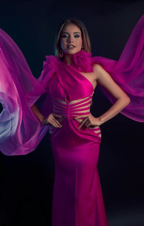 붉은 벽에 핑크색 드레스를 입은 우아한 여성 · 무료 스톡 사진