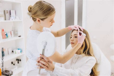 Beautician Marking Injection Points On Womans Forehead Before Botox