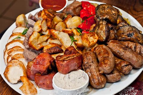 접시에 모듬 된 고기가 닫힙니다 힙에 고기와 감자의 다른 유형 소스를 곁들인 큰 접시에 애피타이저 감자 요리에 대한 스톡 사진