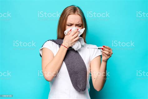 고립 된 배경에 스카프를 입은 젊은 여성이 온도계로 온도를 측정합니다 감기와 독감에 대한 스톡 사진 및 기타 이미지 감기와 독감 건강관리와 의술 건강한 생활방식